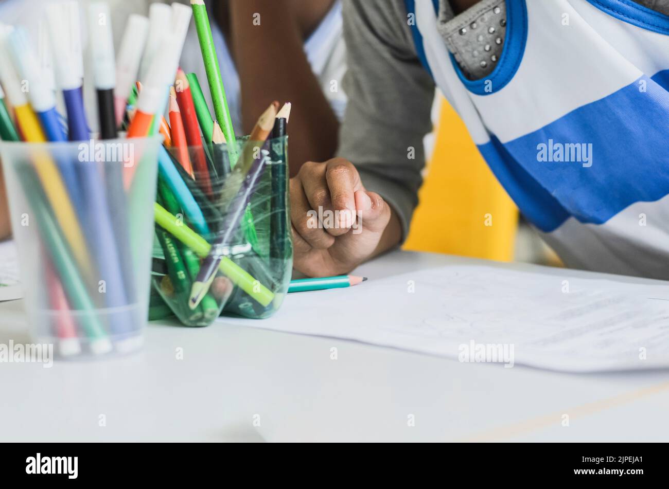 Detail of student hands painting writing with colored pencils. Salvador ...