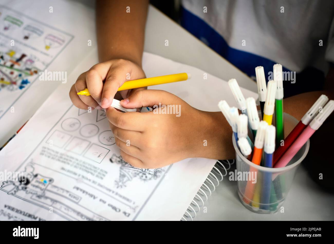 Detail of student hands painting writing with colored pencils. Salvador ...