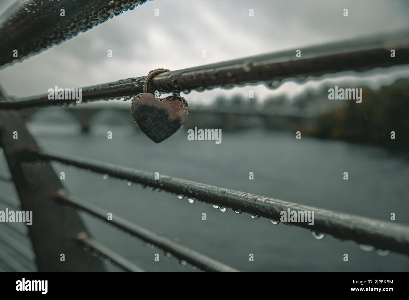 A heart-shaped lock hanging on bridge handrail. Symbol of eternal love ...