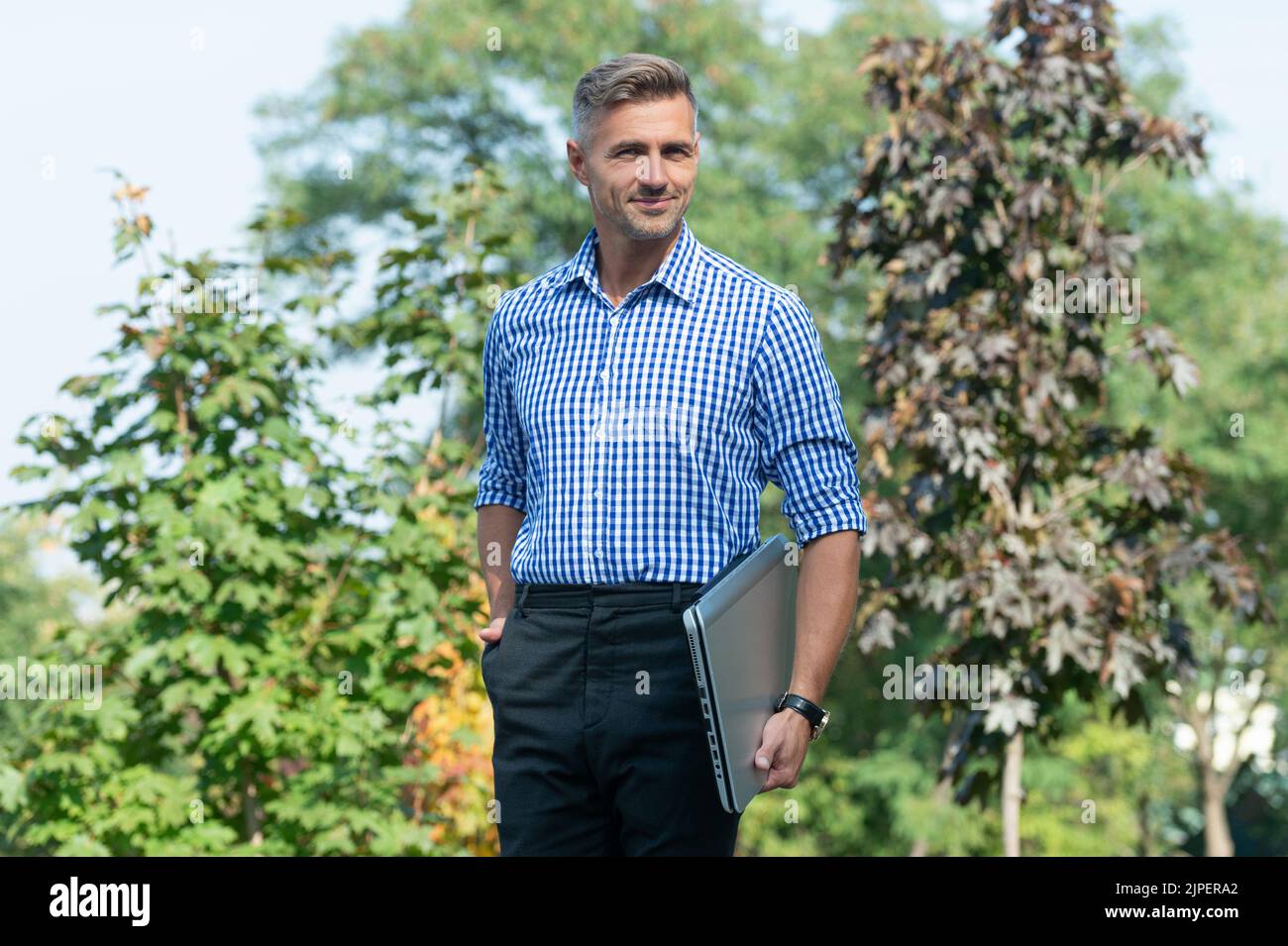 cheerful man hold laptop. man freelancer outdoor. business man with pc ...