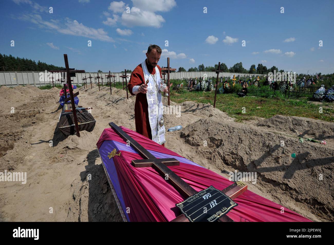 Bucha, Ukraine. 17th Aug, 2022. An Orthodox priest reads a prayer at ...