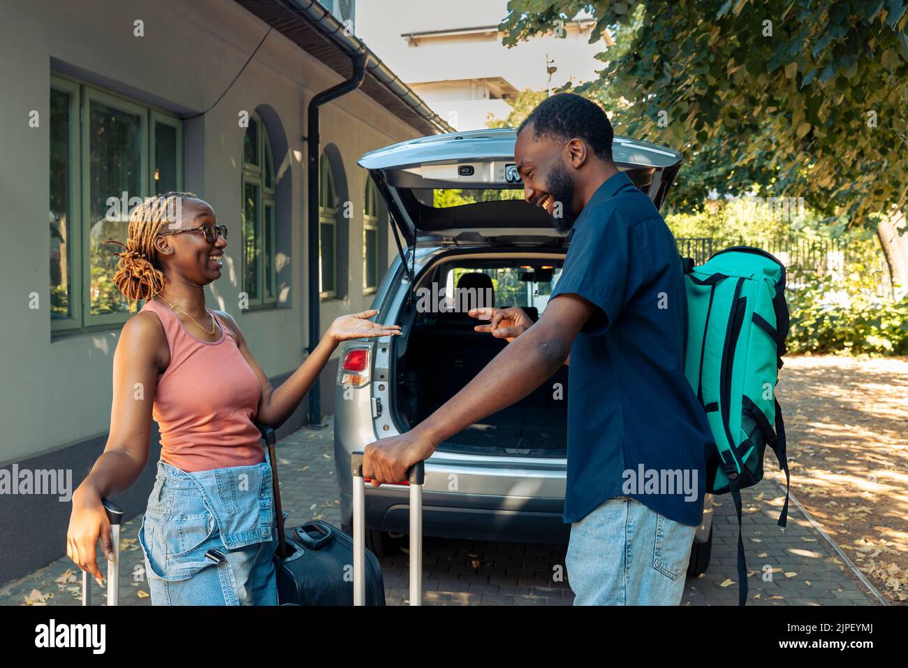 African american partners loading suitcase in trunk, leaving together ...
