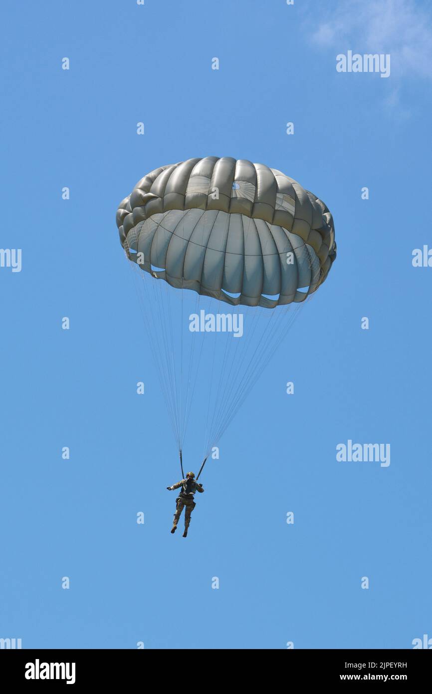 Paratrooper glides down with blue sky behind at Glen Rock Drop Zone ...