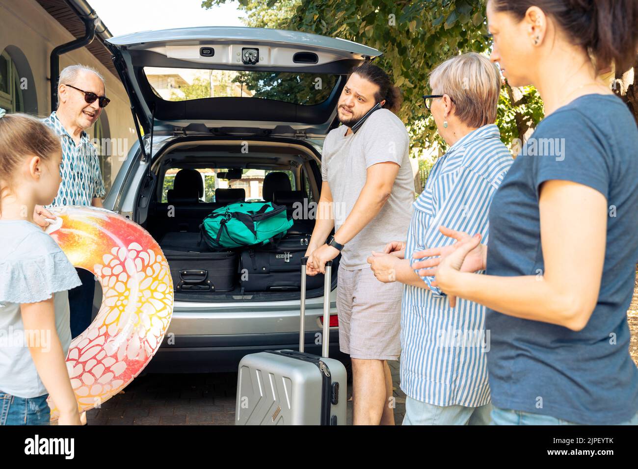 Big family loading baggage in automobile trunk, leaving on holiday ...