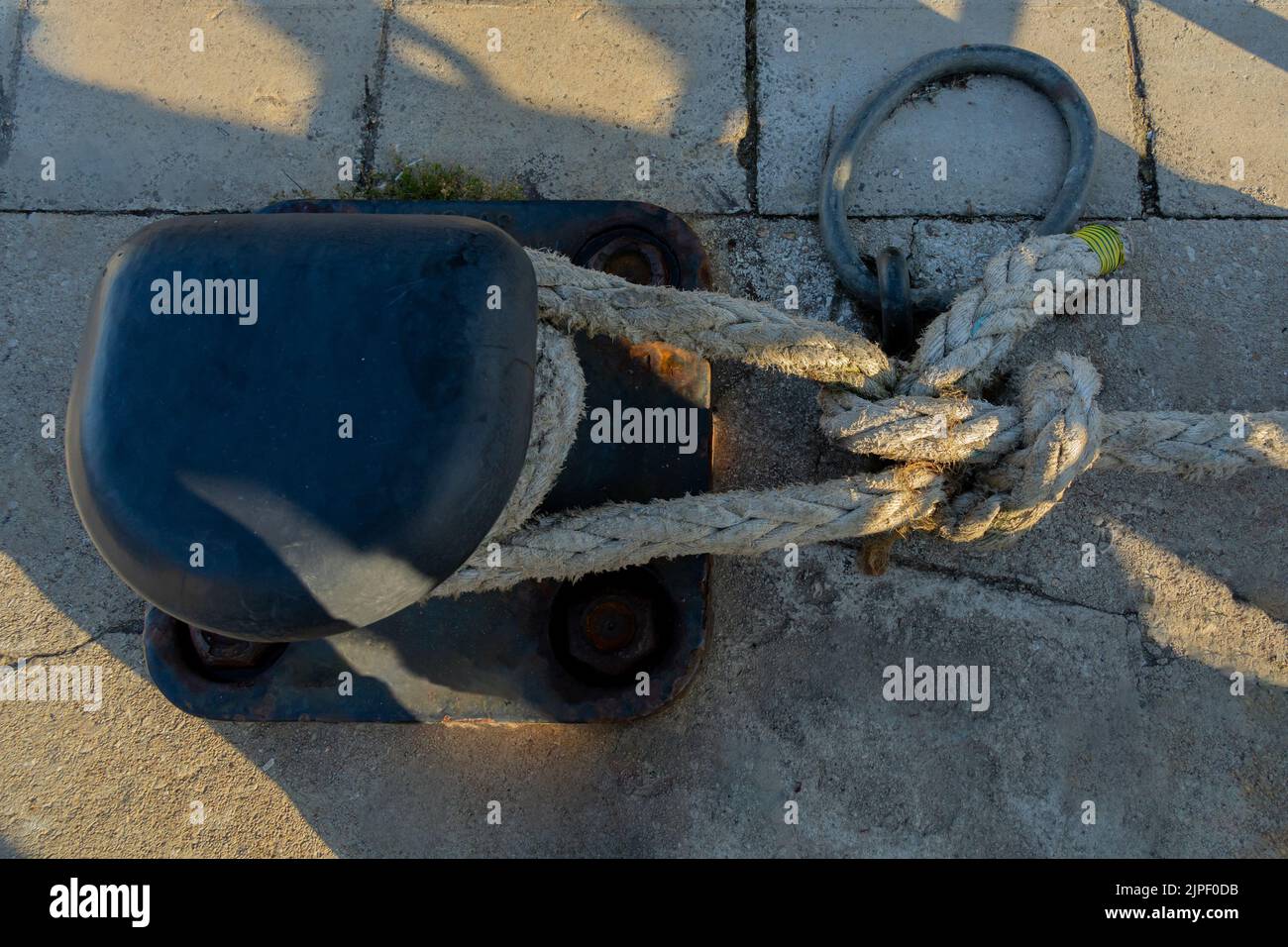 detail of the bollard of a seaport with a rope or rope with knots ...