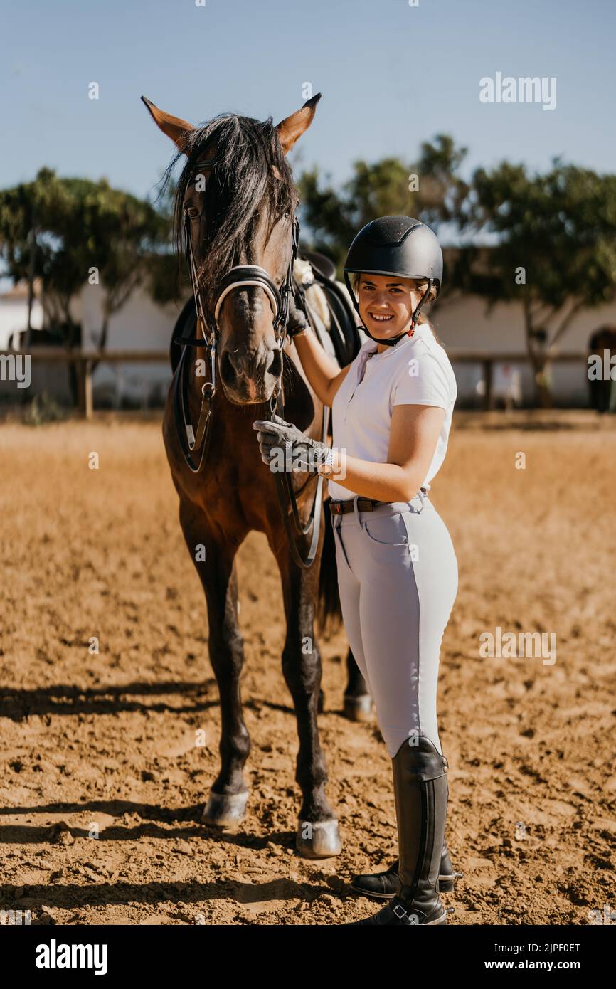 young woman in equestrian dressage clothes posing with her horse in the ...