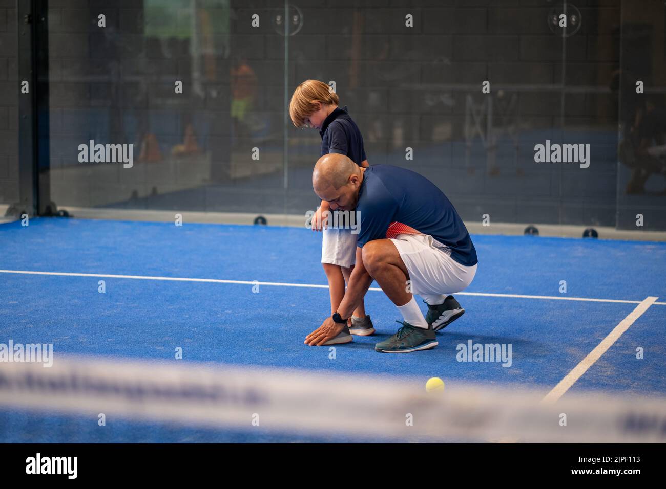 Monitor teaching padel class to child, his student - Trainer teaches ...