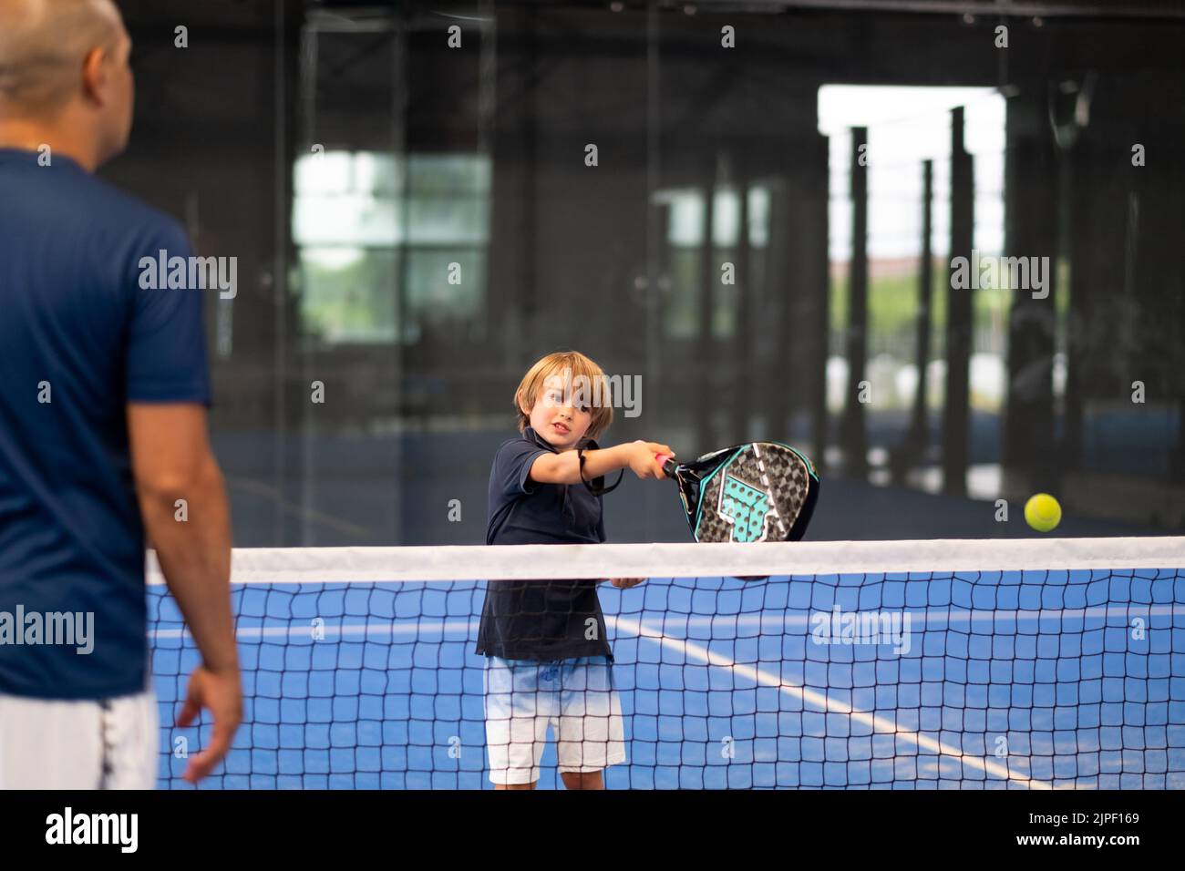 Monitor teaching padel class to child, his student - Trainer teaches ...