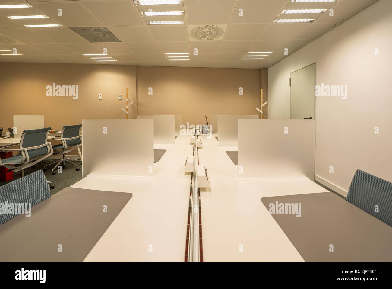 Cubicles in coworking office with table dividers, cable rails, carpet ...