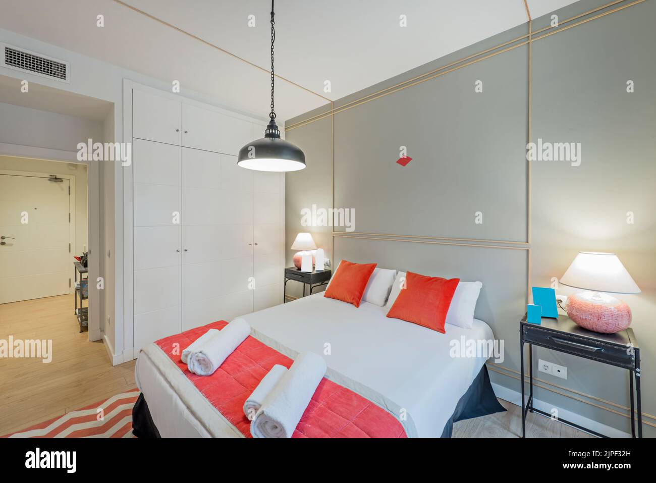 Bedroom with double bed, white built-in wardrobe, wooden edges and red ...