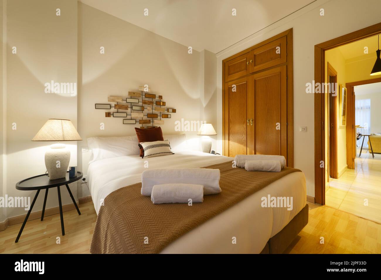 Bedroom with double bed, yellow and white walls, mirrors with black ...