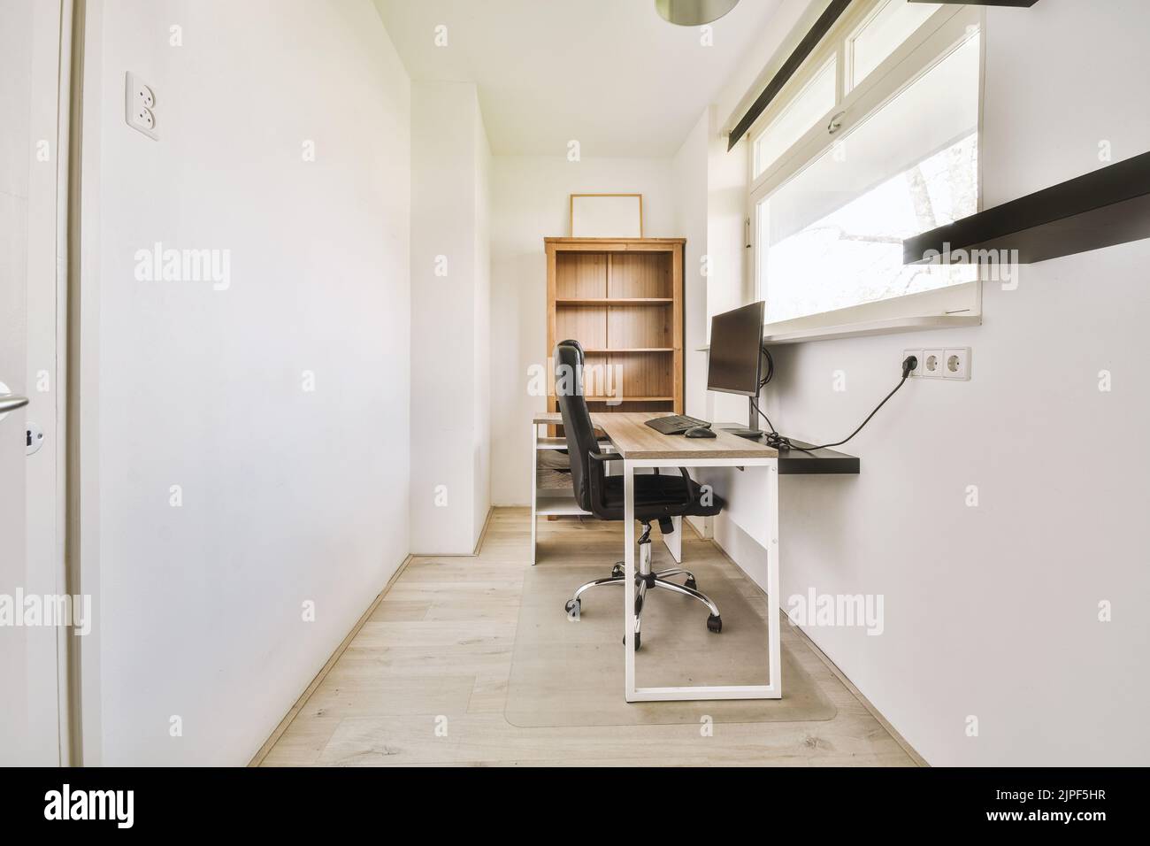 Comfortable chair placed near desk with computer monitors and ...