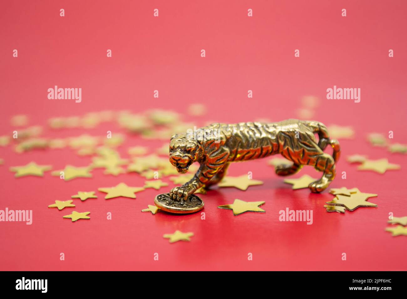 A bronze figure of a tiger with a coin - the symbol of financial well ...