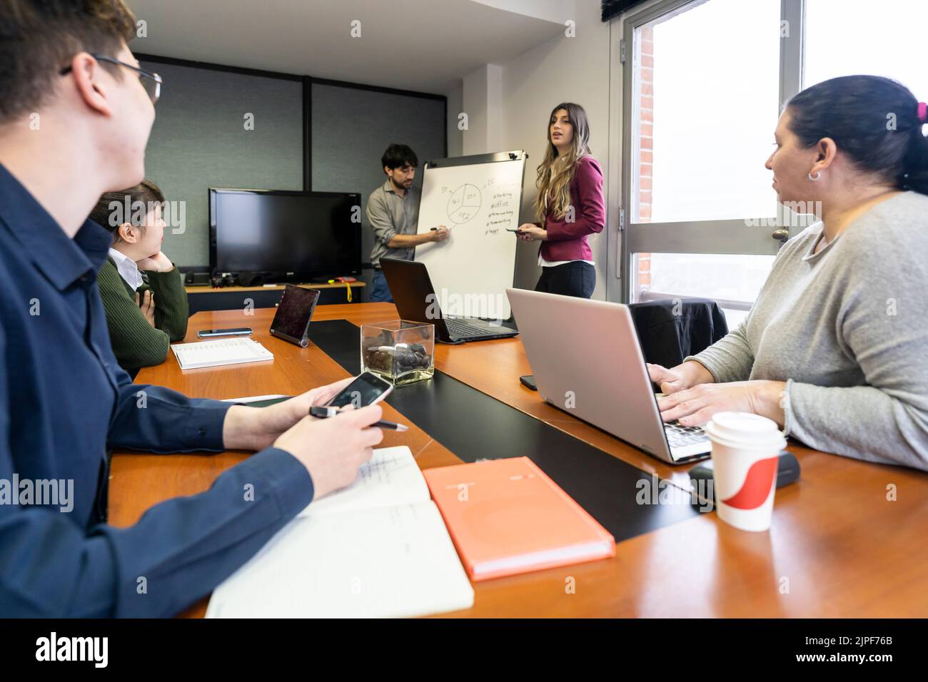 Employees making a presentation to their office colleagues in the ...
