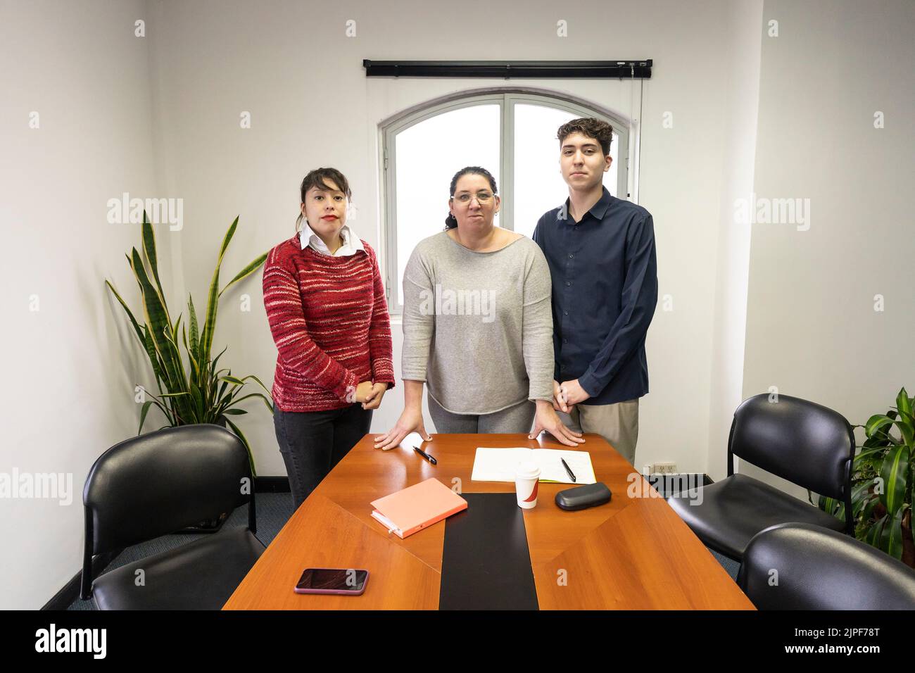 Group of employees standing at end of table in office meeting room ...