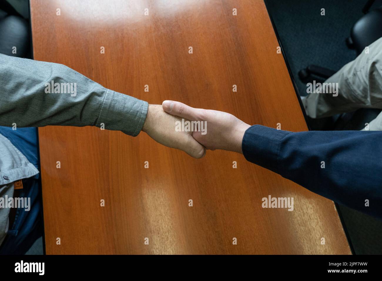 Close-up overhead shot of two men shaking hands. Concept of deal ...