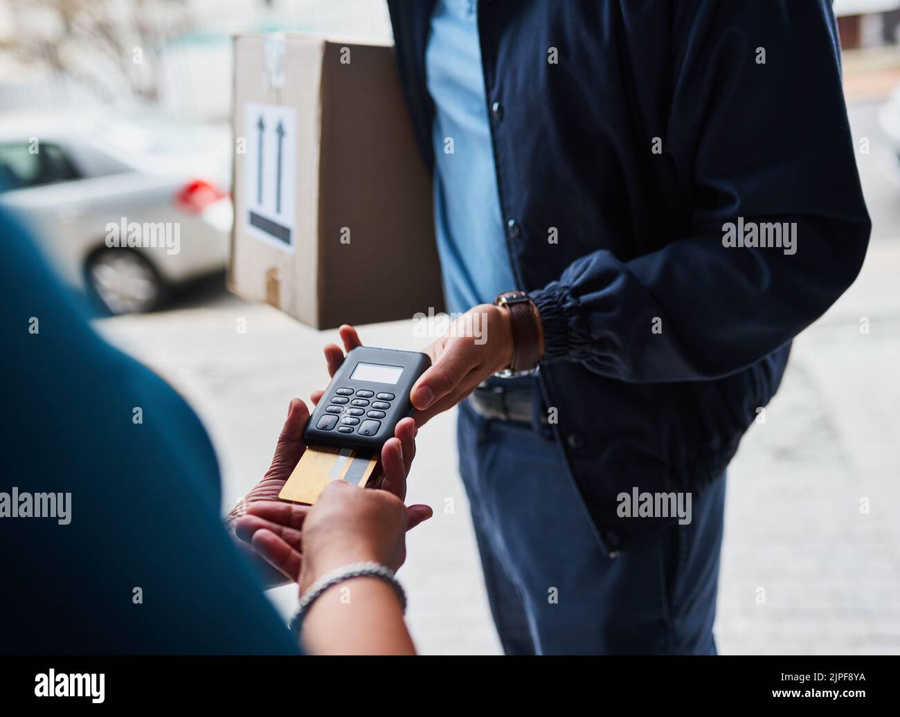 Paying the easy way. an unrecognizable man delivering a package to a ...