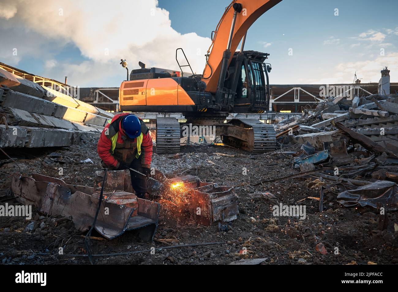 Worker in helmet cuts old metal beam for recycling at site Stock Photo ...
