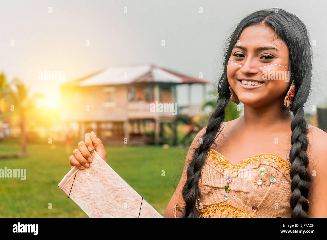Indigenous beauty queen holding a white band and wearing traditional ...
