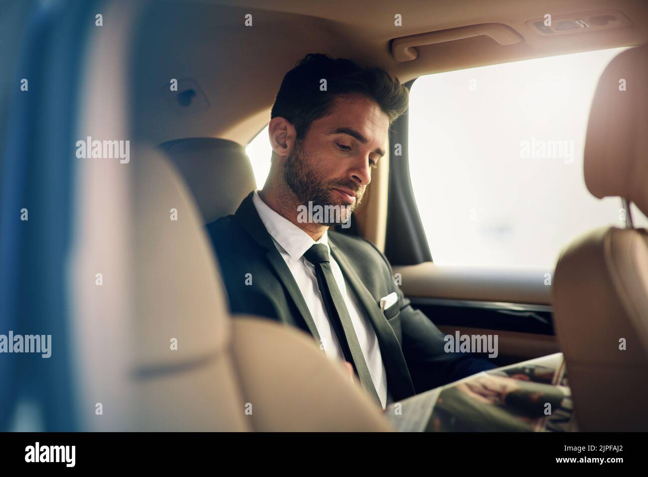 On route to the office. a confident young businessman reading the ...