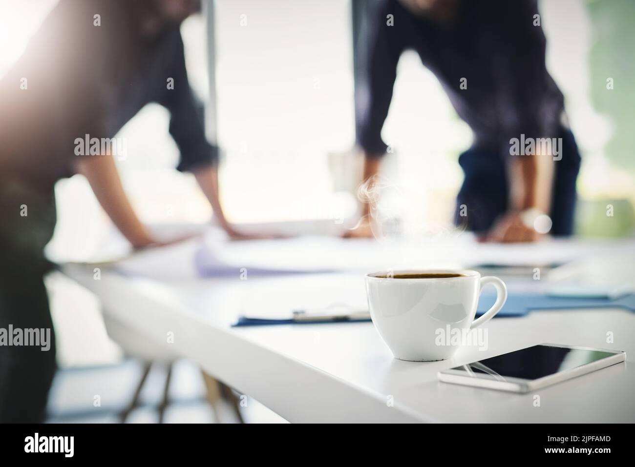 Its one busy work day. two unrecognizable businessmen working through ...