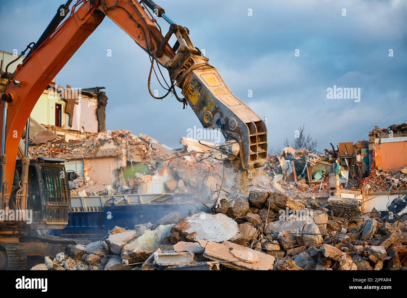 Crusher destroys reinforced concrete at demolition site Stock Photo - Alamy