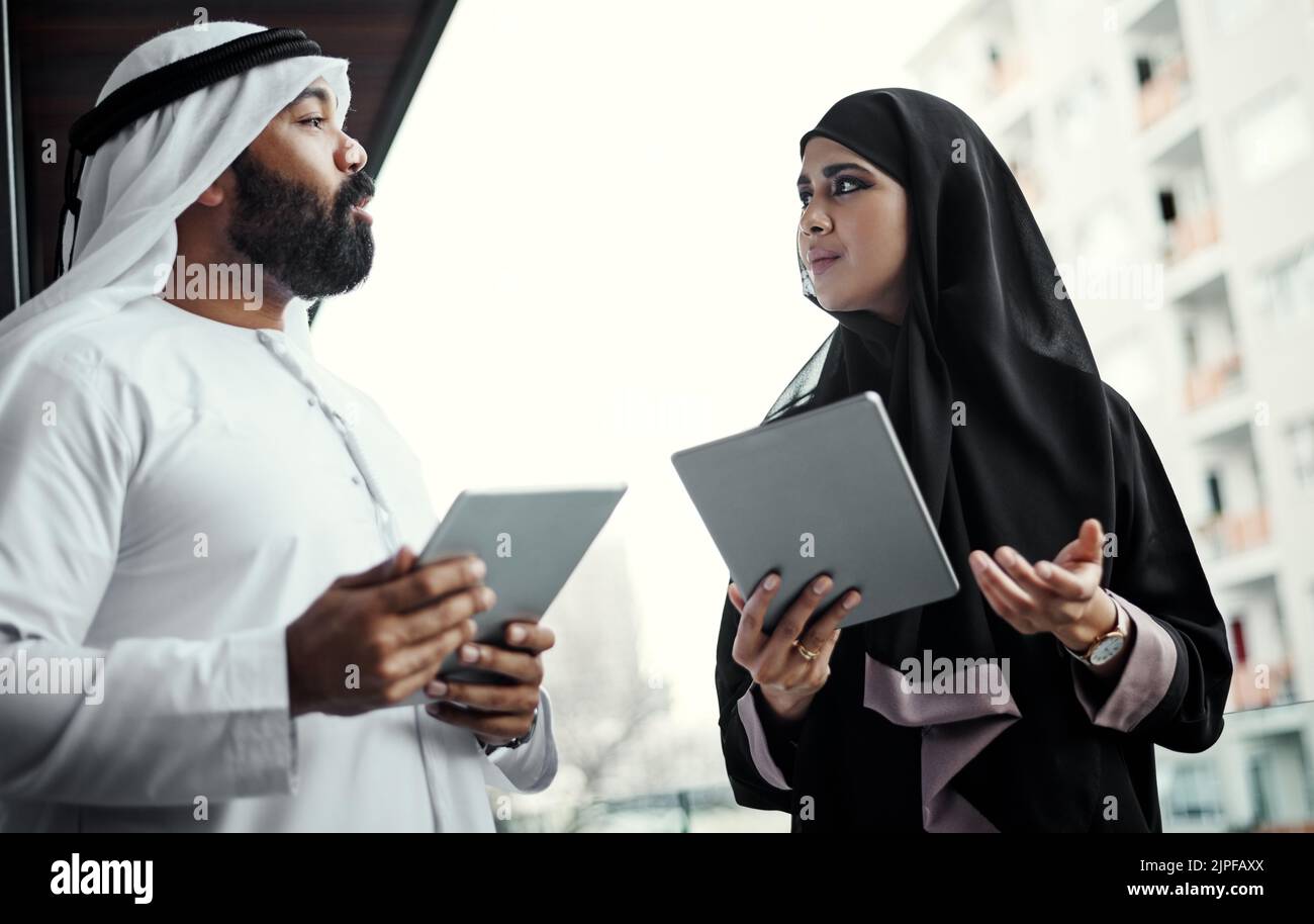 They work well together. two young businesspeople dressed in Islamic ...