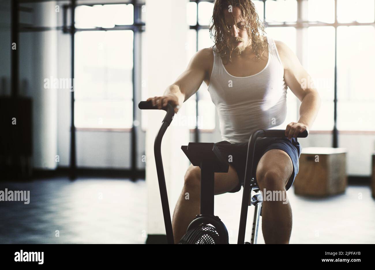 Hes feeling the burn. a handsome young man working out on an elliptical ...