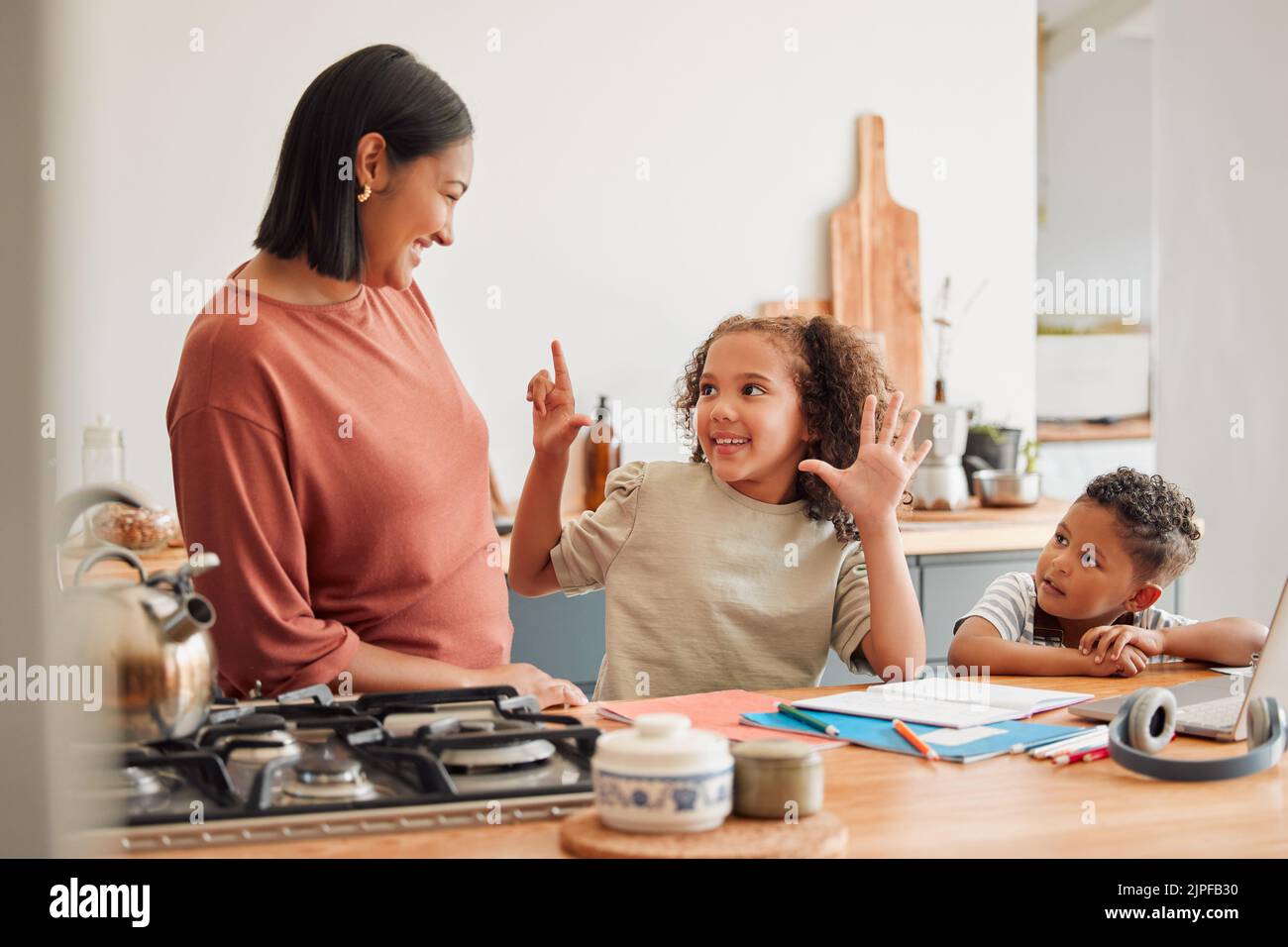 A mother smiling, teaching and helping children with homework in the ...