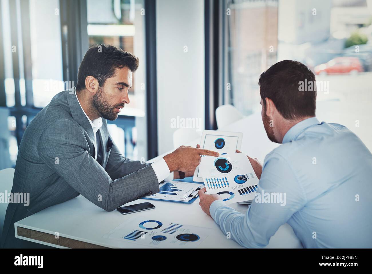 The answers lie in the data. two young businessmen going through ...