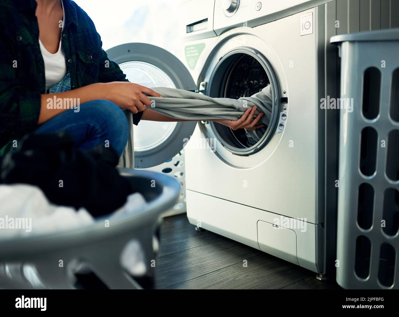 Time to get this dried. a young woman doing her laundry at home Stock ...
