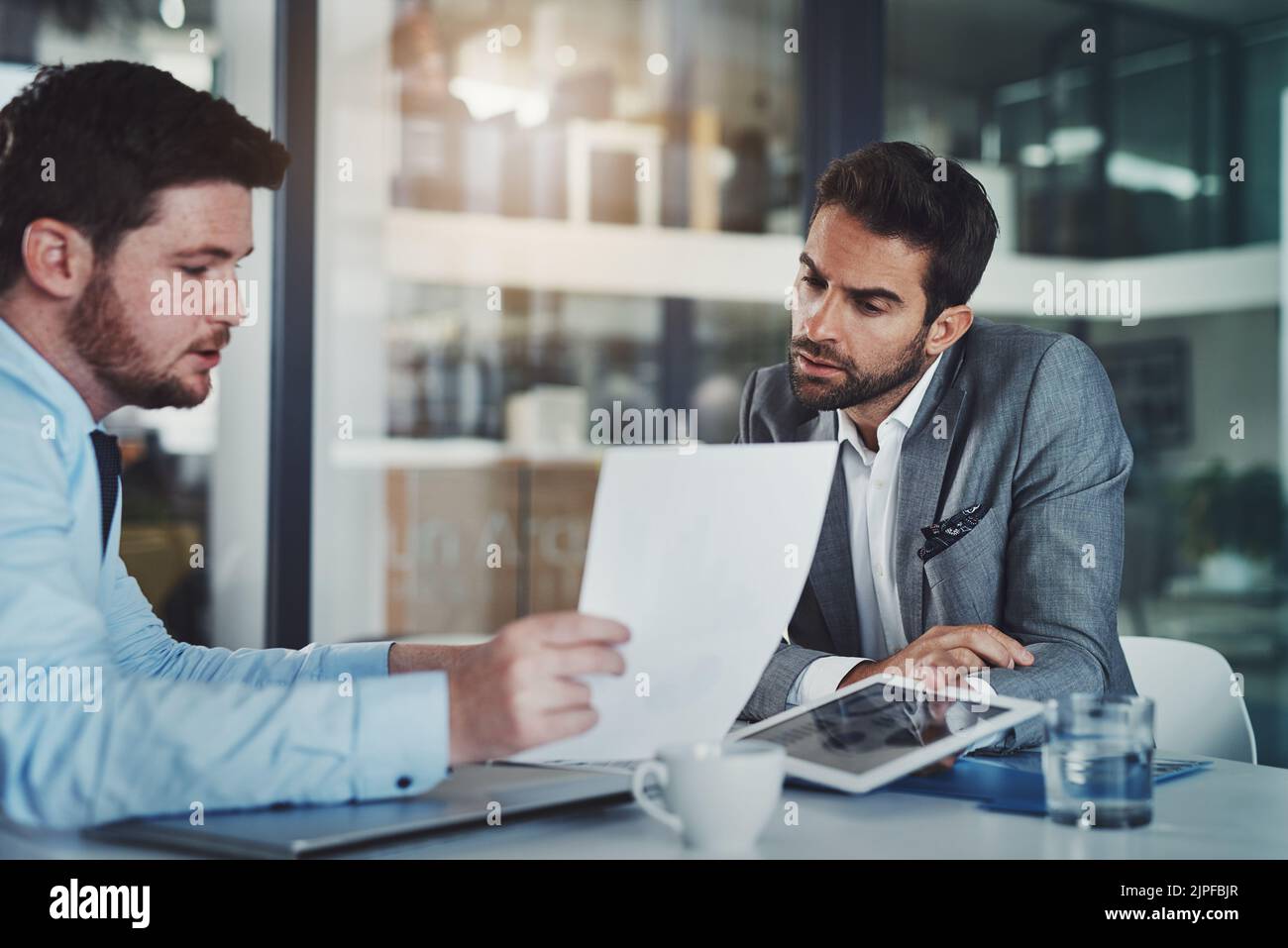 The numbers are hard to ignore. two young businessmen going through ...