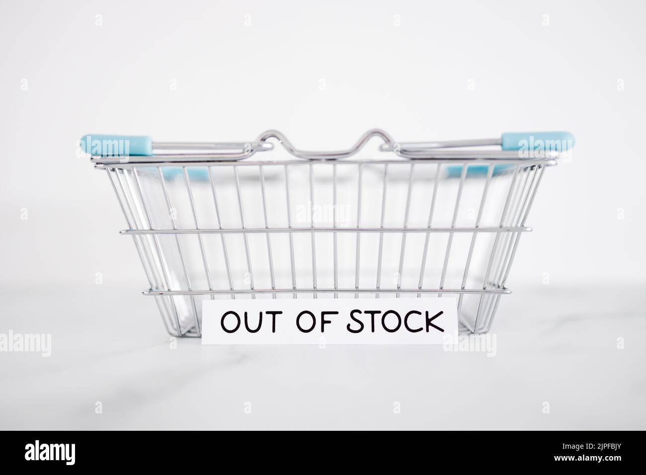out of stock text in front of empty shopping basket on white background ...