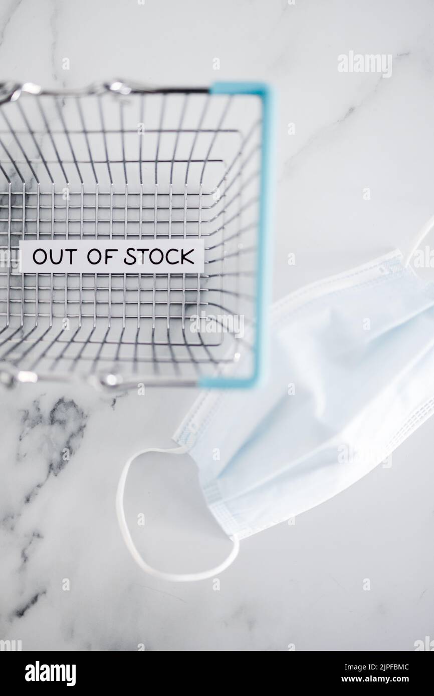 out of stock text in front of empty shopping basket with surgical mask ...