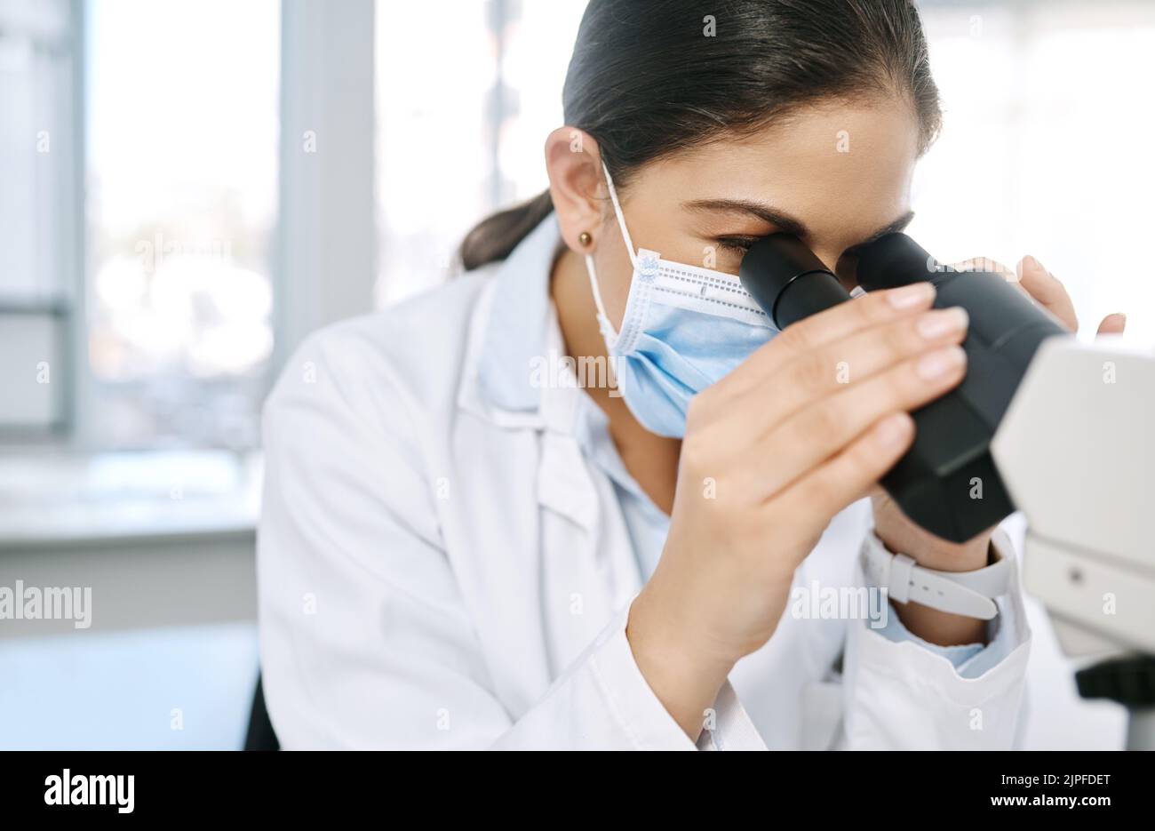Its vital to have a critical eye in the lab. a young scientist using a ...