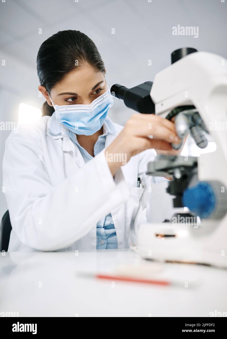 Every sample is vital to her study. a young scientist using a ...