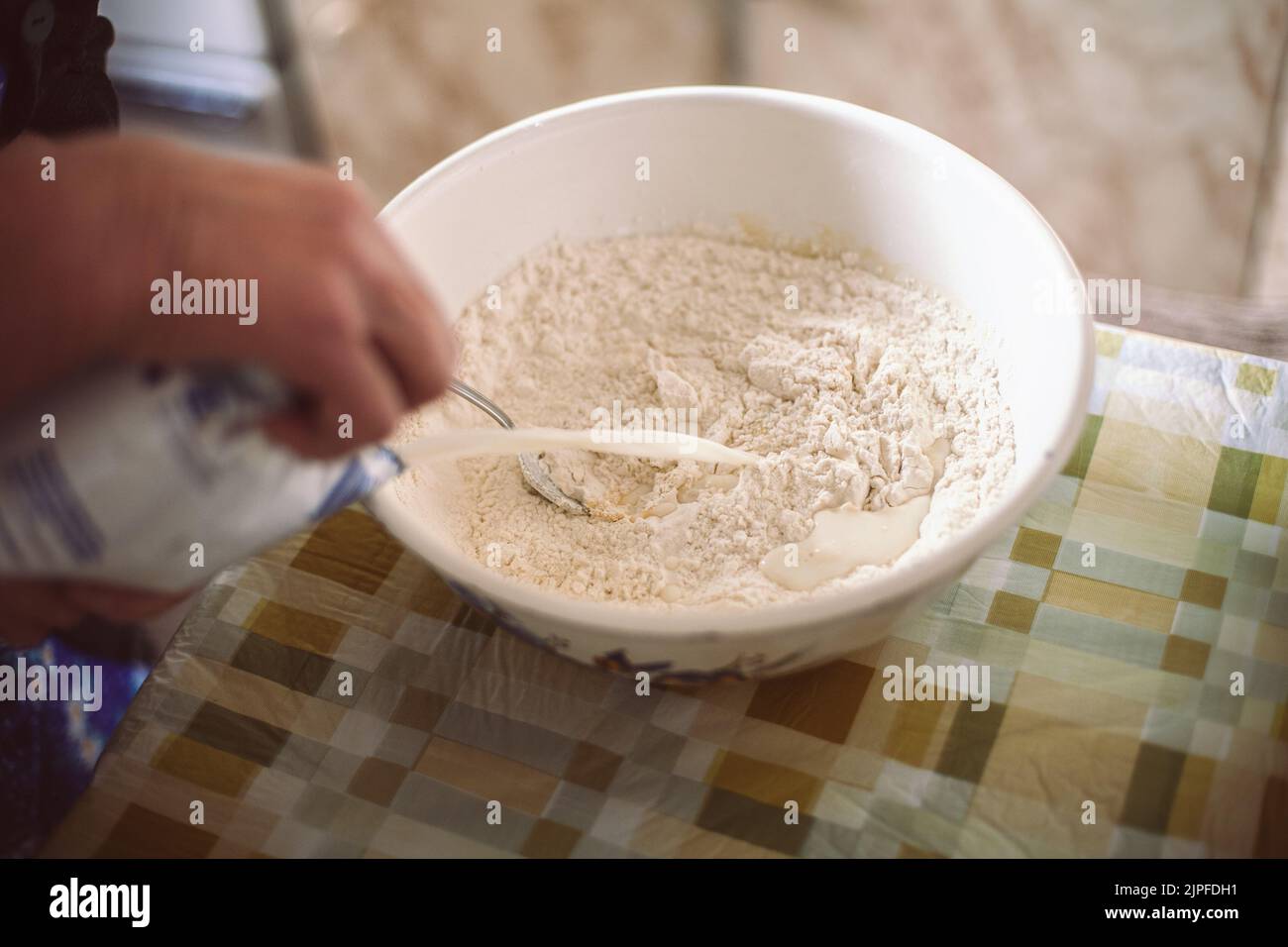Grandmother pouring milk into pancake batter Stock Photo - Alamy