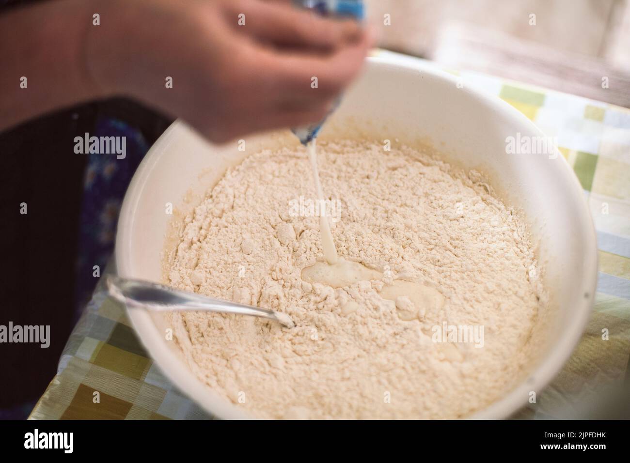 Grandmother pouring milk into pancake batter Stock Photo - Alamy