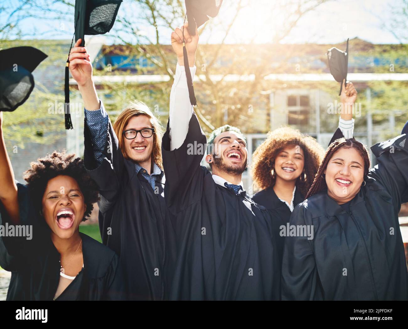Theres no stopping us now. a group of students throwing their caps into ...