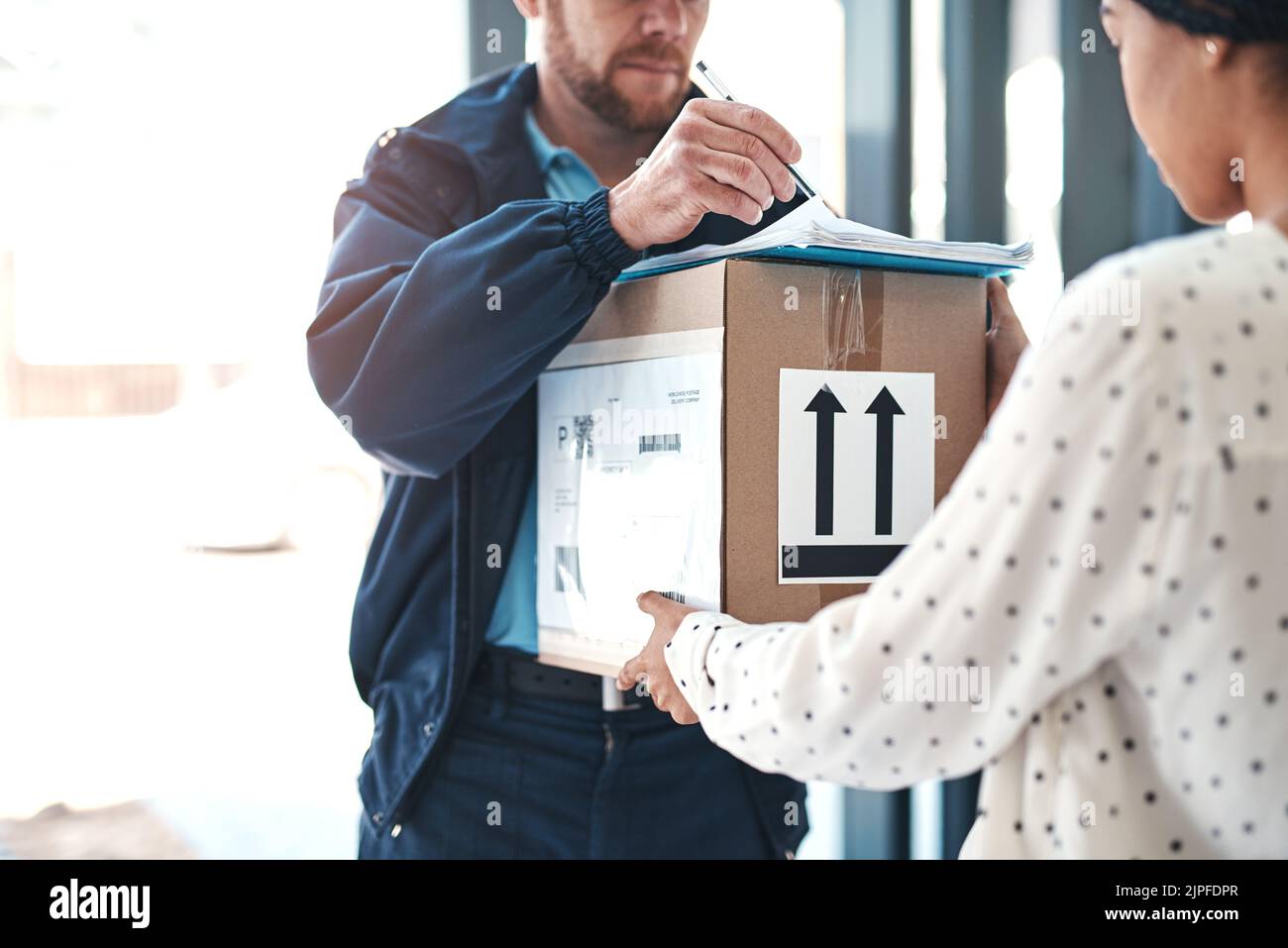 This where youll need to sign. an unrecognizable delivery man handing a ...
