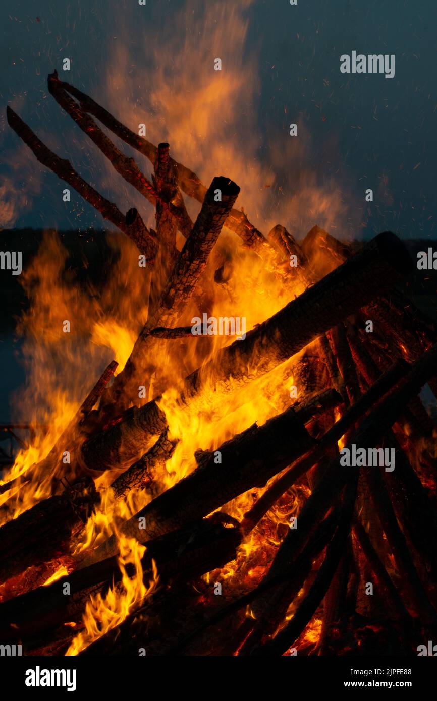 A vertical shot of flaming woods at a bonfire during nighttime Stock ...