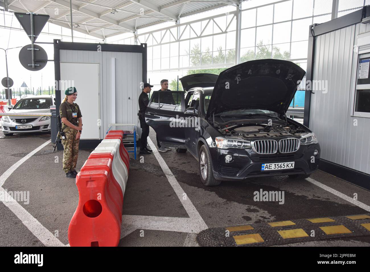 Border guards and the police inspect a car at the border crossing point ...