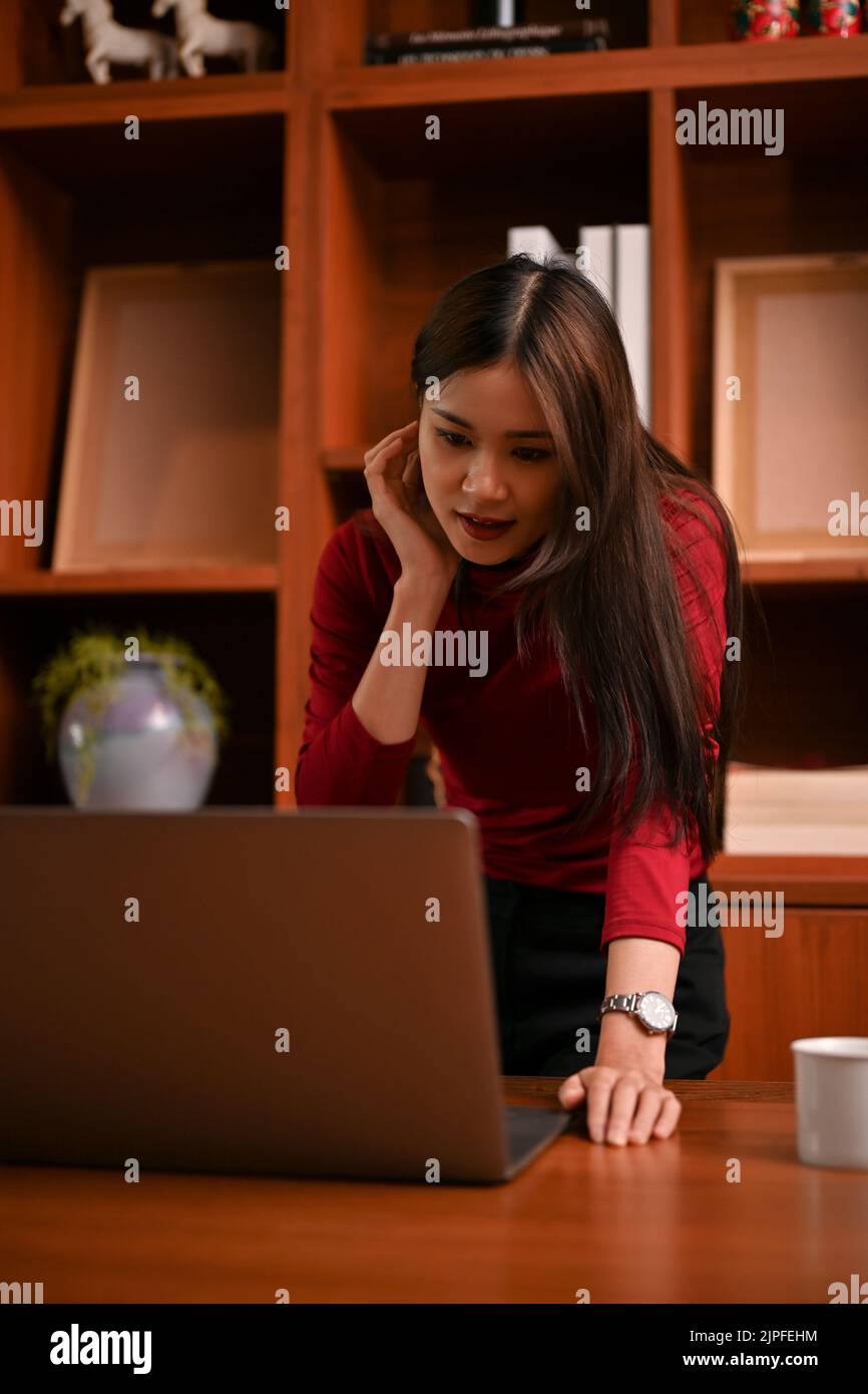 Talented young Asian businesswoman or female manager leaning over her ...