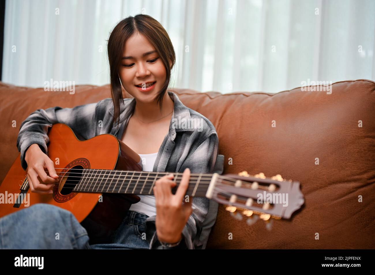 Charming young Asian female artist singing her favourite song while ...