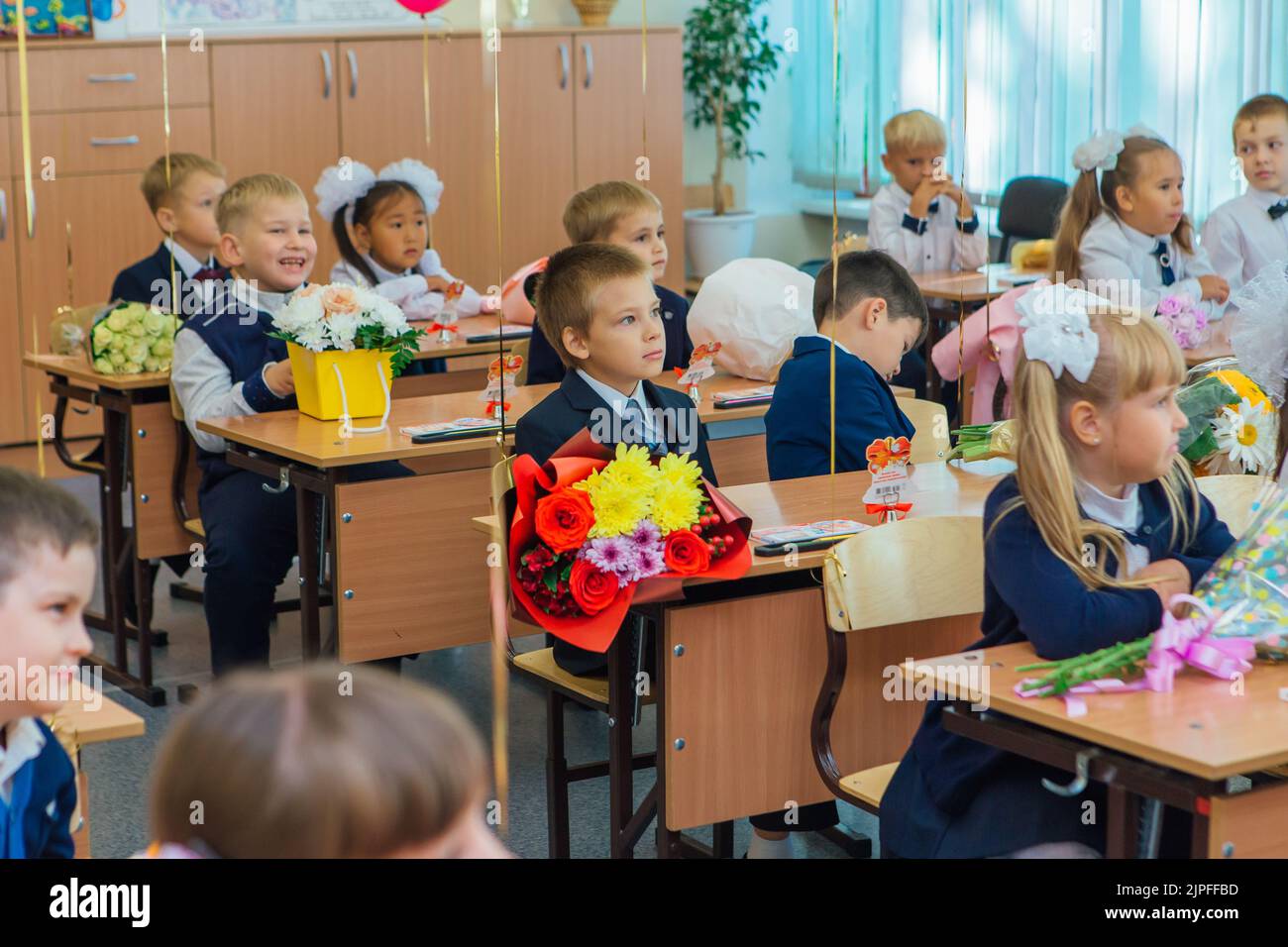 First-grade students and teacher are in school classroom at first ...