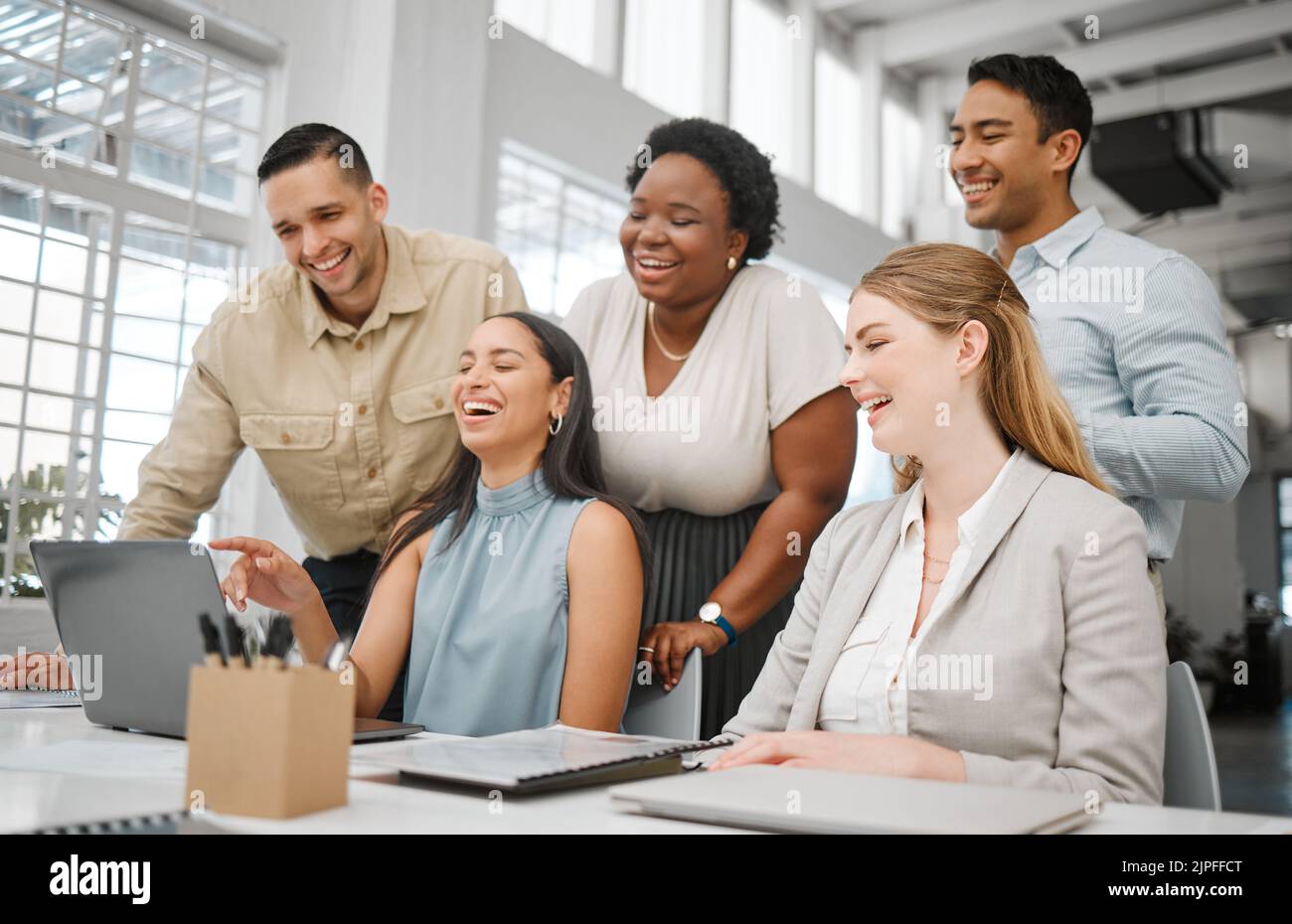Cheerful, joyful professional business people looking at laptop ...