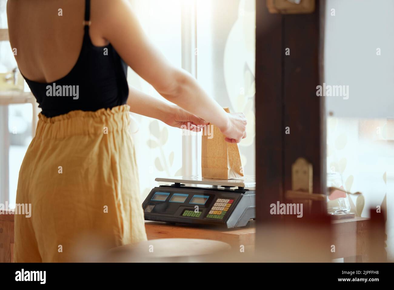 Employee, entrepreneur or business owner weighing or scaling a product ...