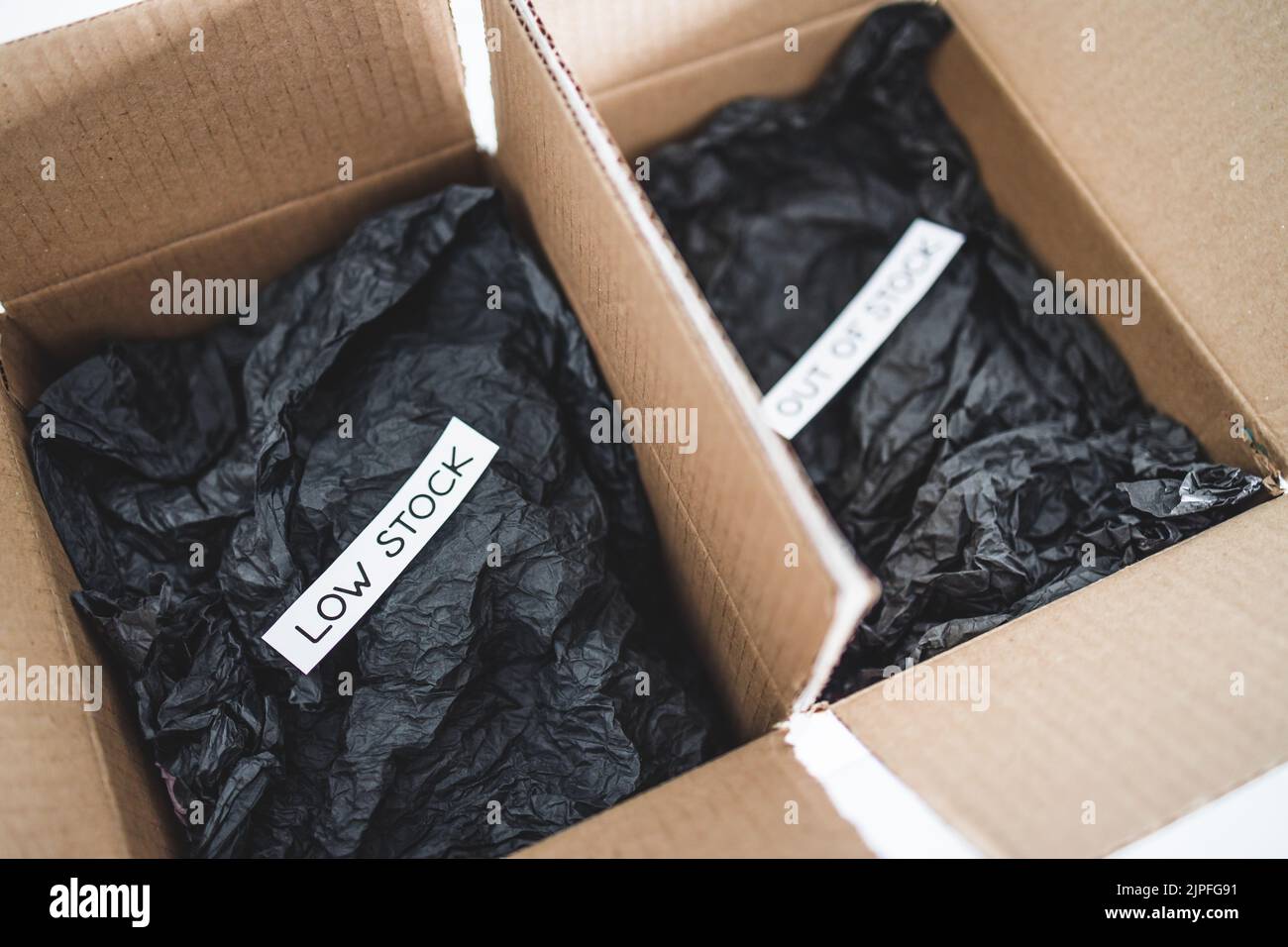 Low stock and out of stock texts inside of empty delivery parcels with ...