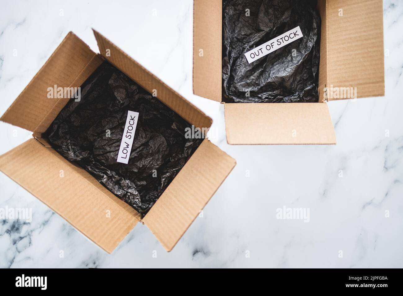 Low stock and out of stock texts inside of empty delivery parcels with ...