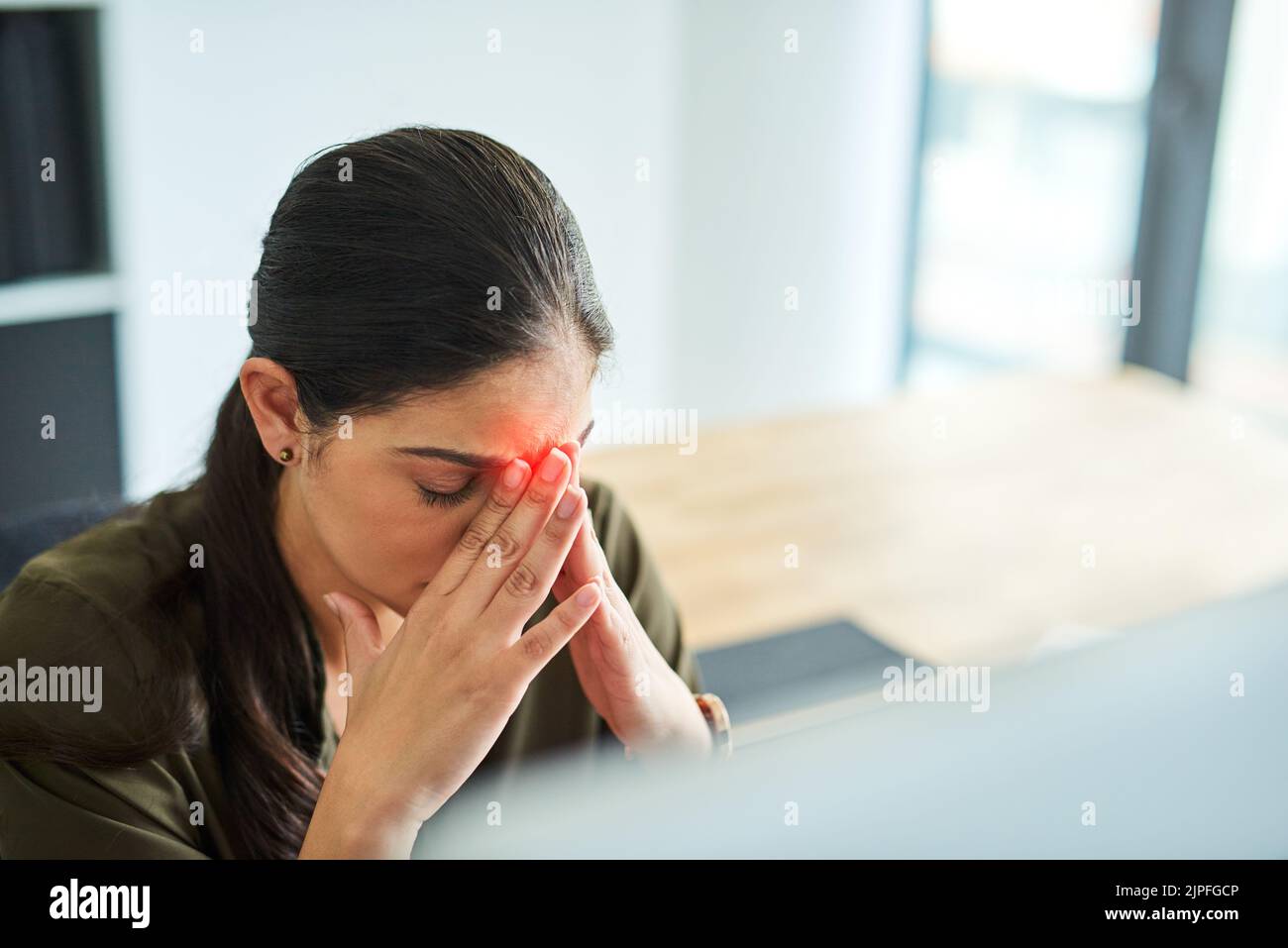 Hit by another headache. a young businesswoman suffering with a ...